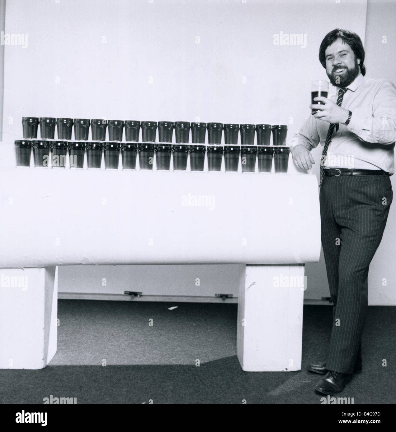 Journalist Alister Martin stands beside counter with 33 pints of beer ...