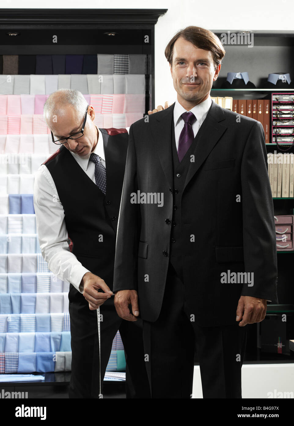 A tailor fitting a man with a suit Stock Photo - Alamy