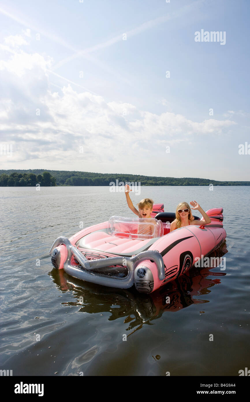 Two children in an inflatable raft on a lake Stock Photo - Alamy