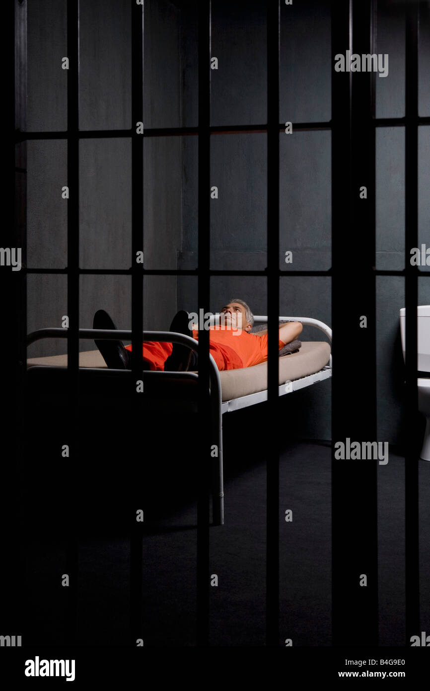 A prisoner lying on his bed in a prison cell Stock Photo - Alamy