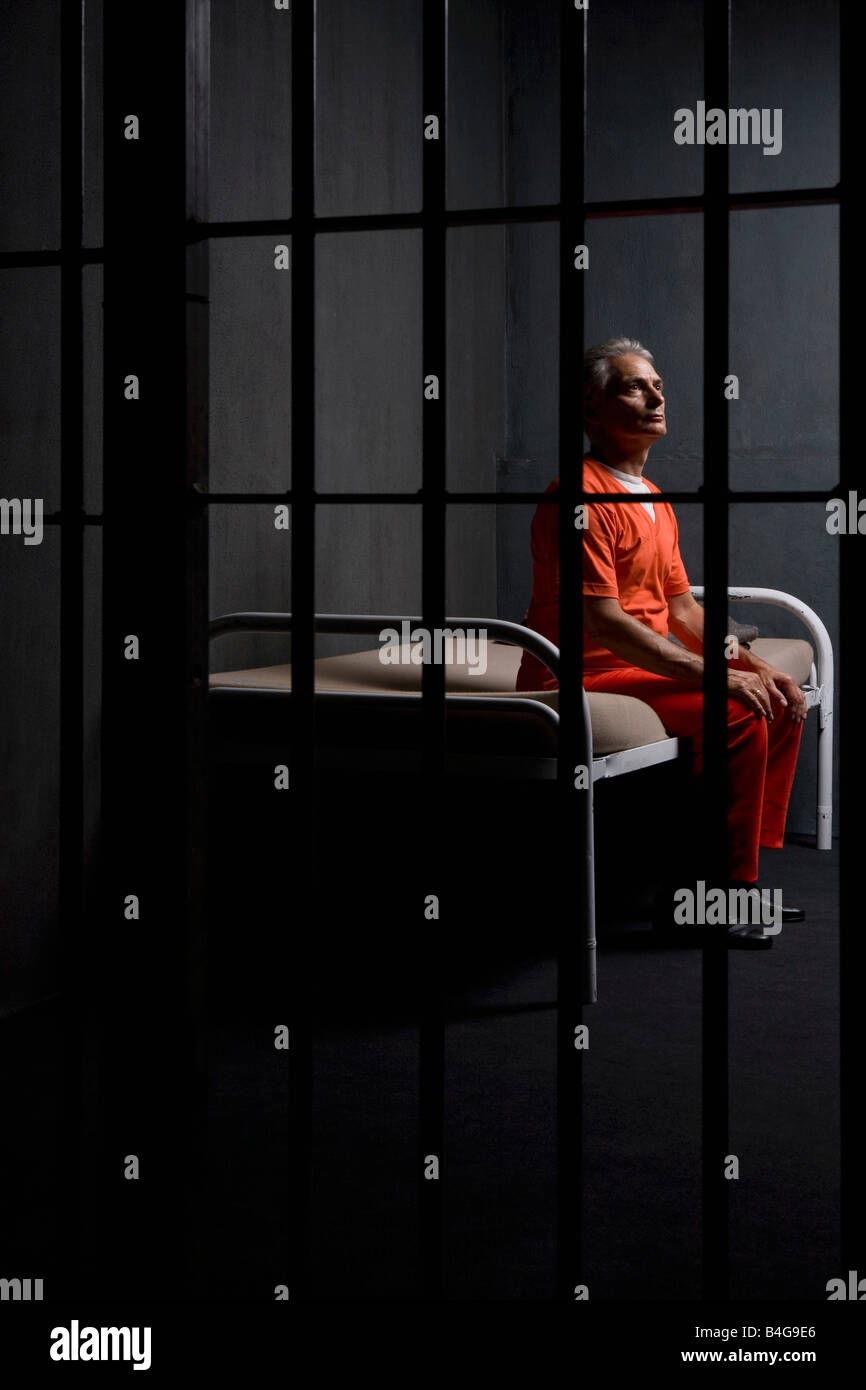 A prisoner sitting on a bed in a prison cell Stock Photo - Alamy