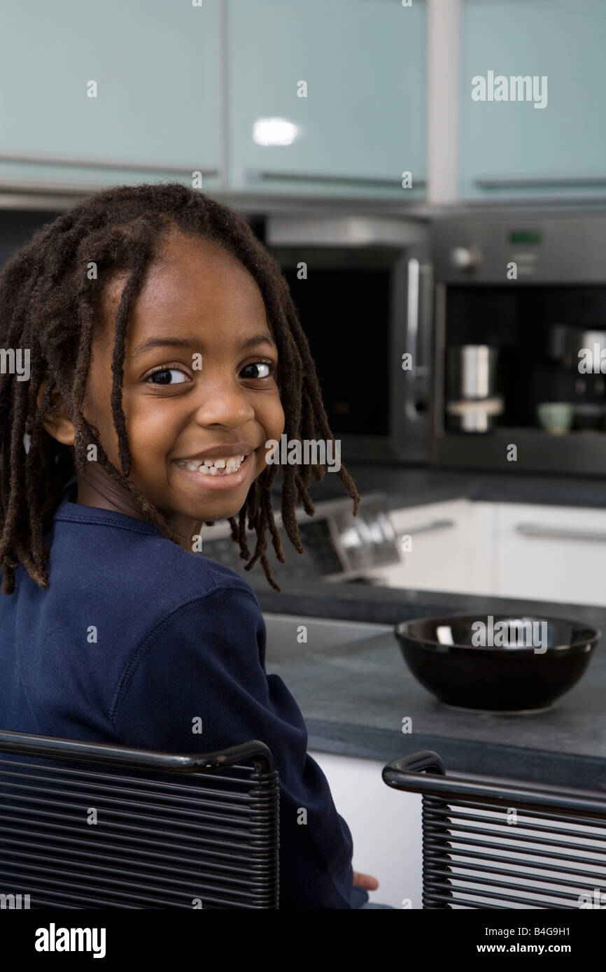 A young boy sitting at a kitchen counter Stock Photo - Alamy