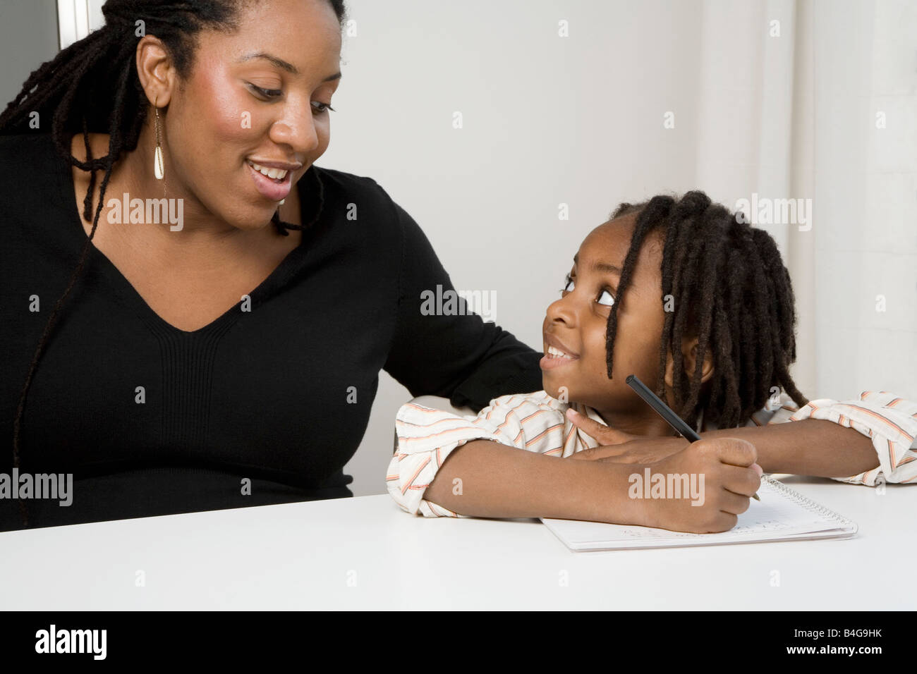 A mother watching her son writing Stock Photo - Alamy