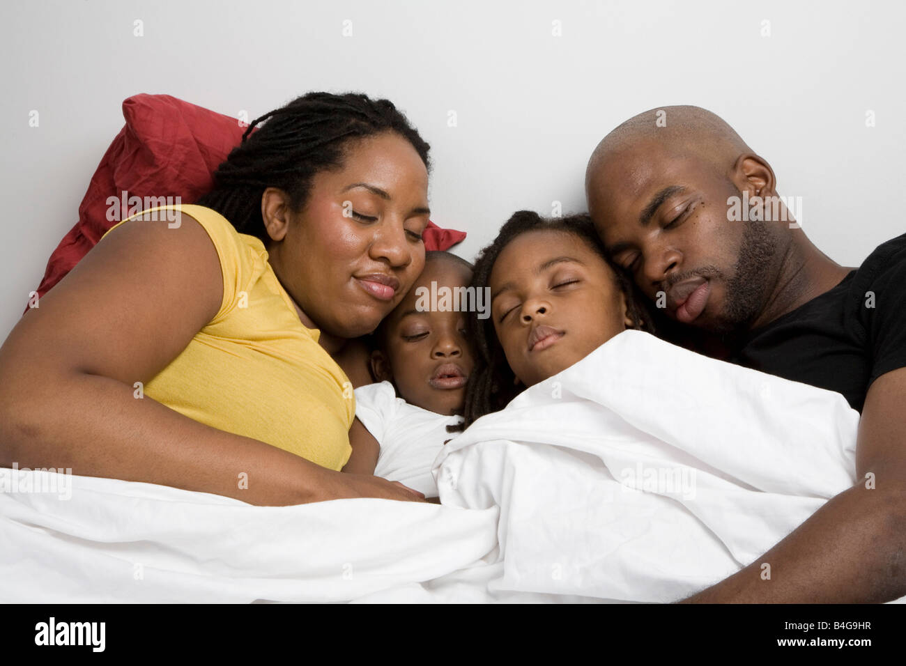 A family four sleeping in bed together Stock Photo - Alamy