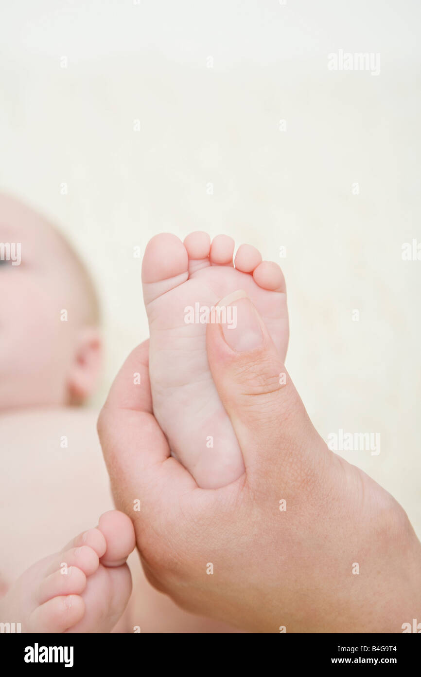 A human hand holding a baby's foot Stock Photo - Alamy