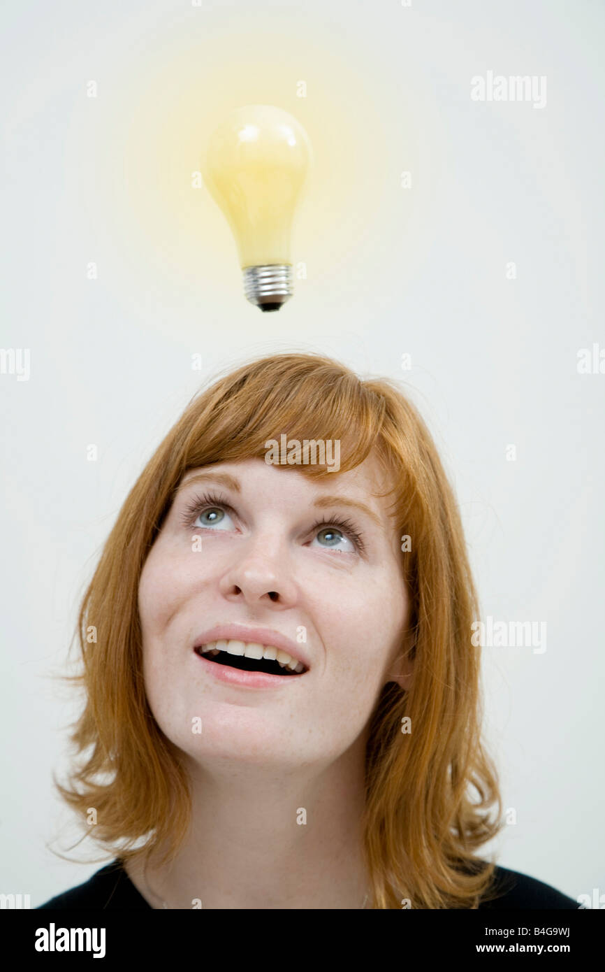 A young woman with a light bulb over her head Stock Photo - Alamy