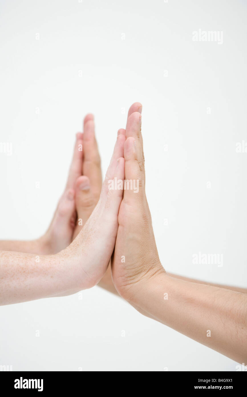 Two people's hands pressed up against each other, unrecognizable people ...