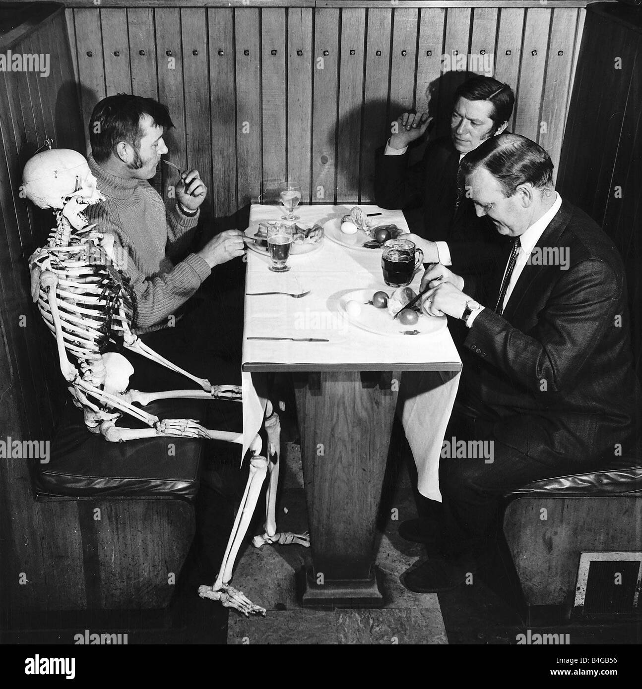 Skeleton sits at table in pub waiting to be served Stock Photo - Alamy