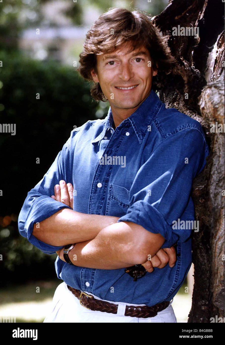 Nigel Havers actor leans against tree Stock Photo - Alamy