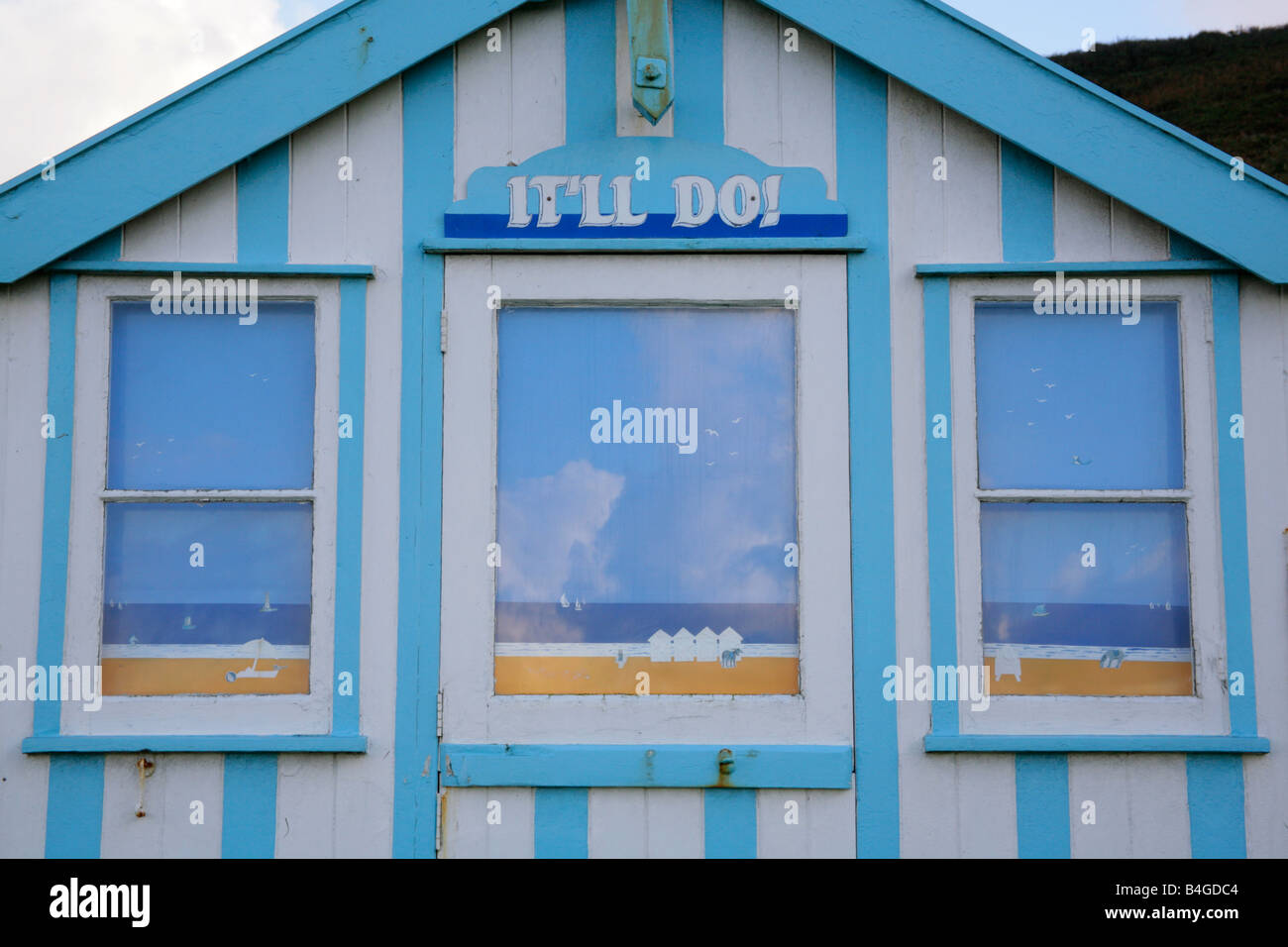 Traditional striped chalet beach hut with seaside holiday scenes ...