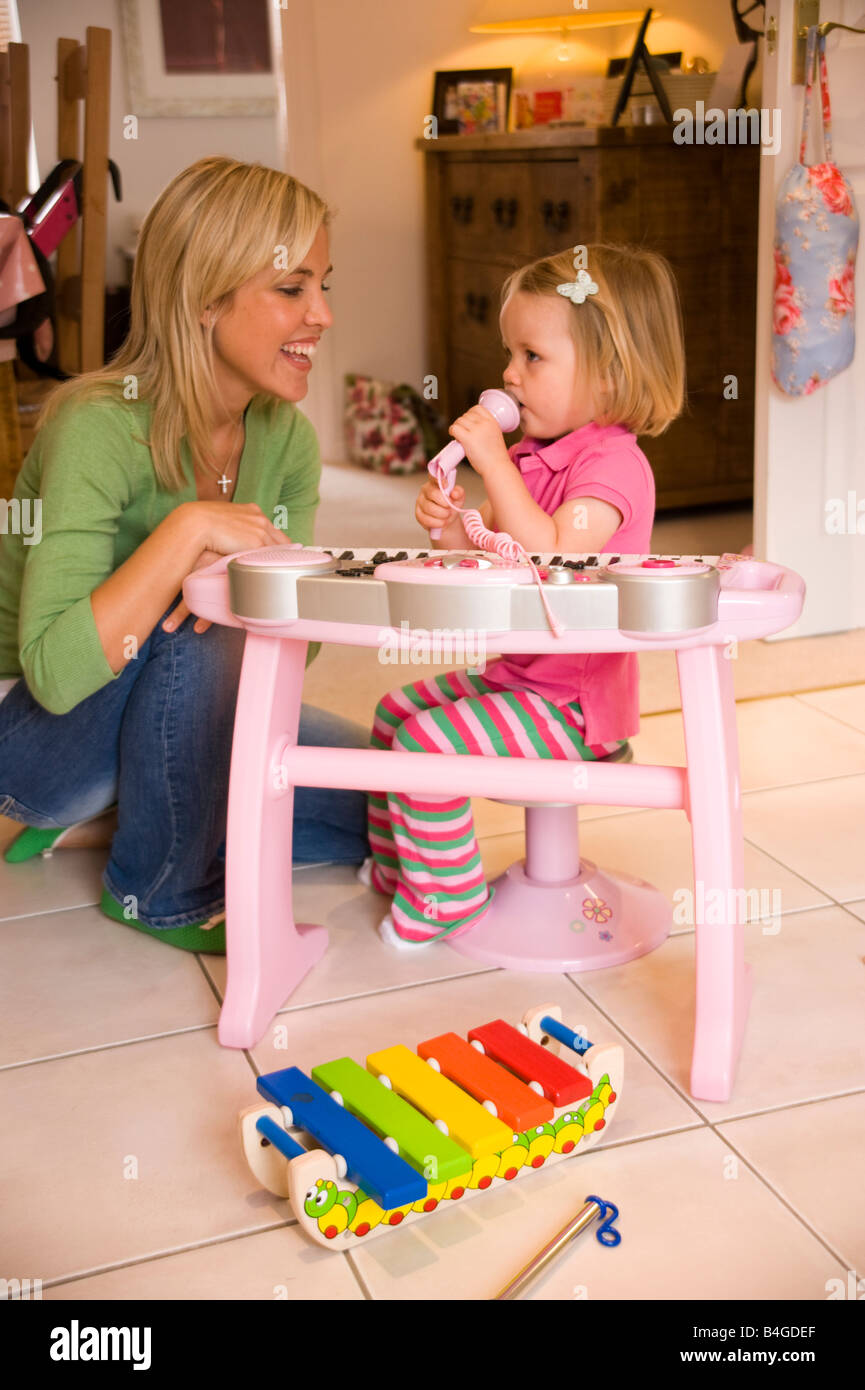 little girl and her mother playing on a toy sound system Stock Photo ...