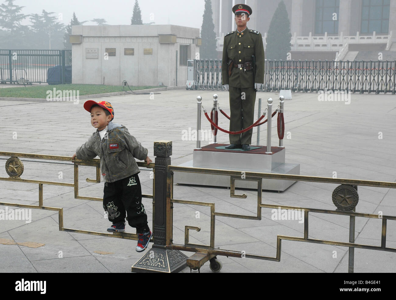 Chinese boy poses for a photograph in front of guard in Tianamen Square ...