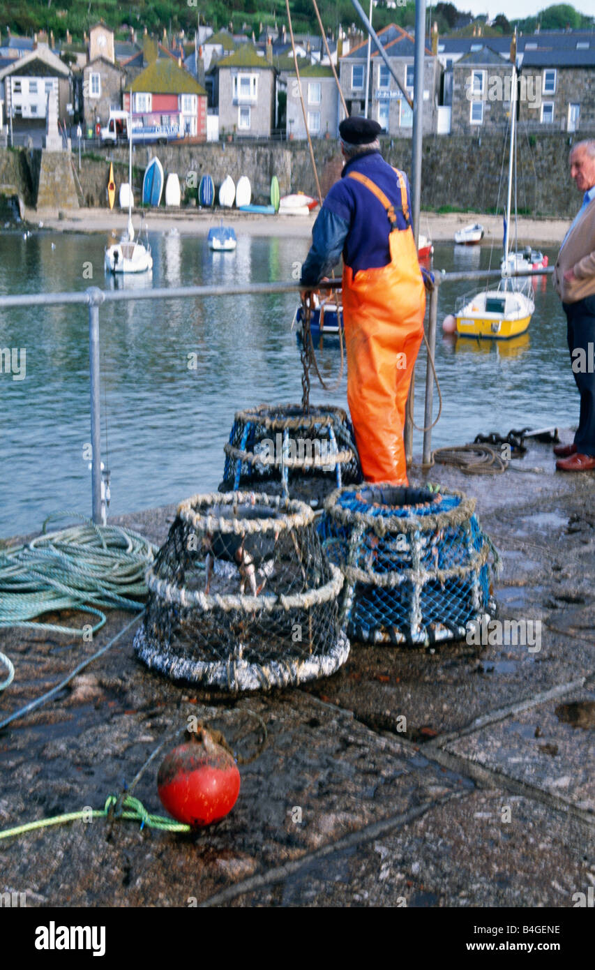 Fisherman with lobster creels on the quay at Newyln Harbour in Cornwall ...