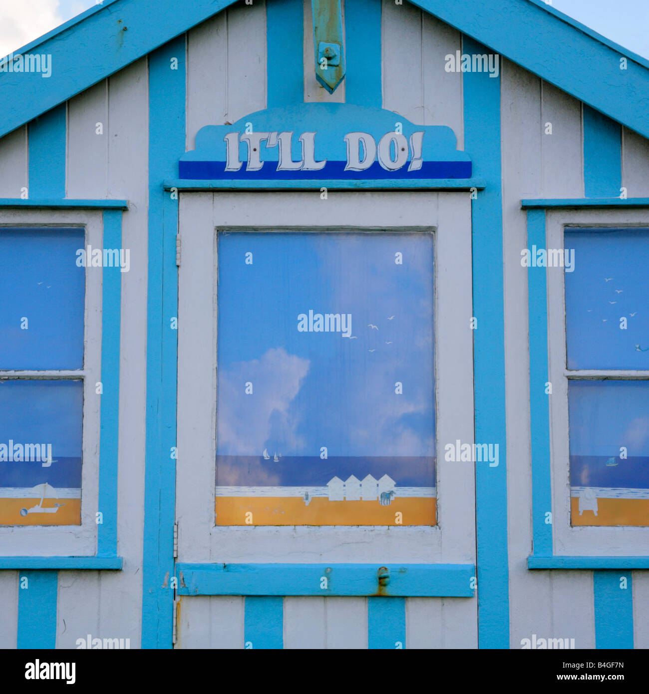 Traditional striped chalet beach hut with seaside scenes painted on ...