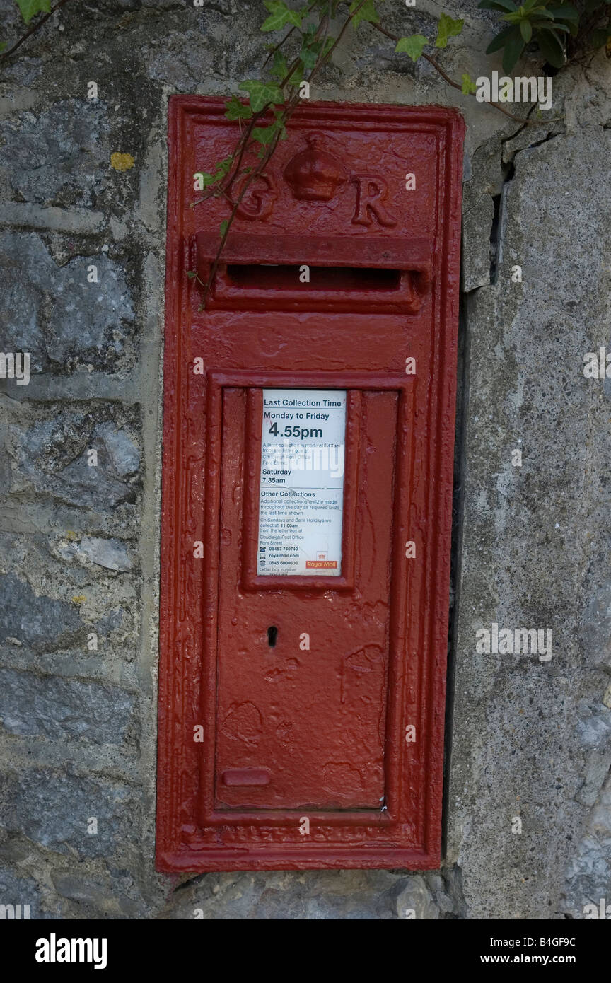 Historic red post box built into a stone wall in Devon, south west ...