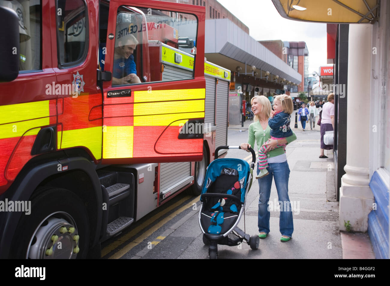 mother and little girl looking at a fire engine and talking to the ...