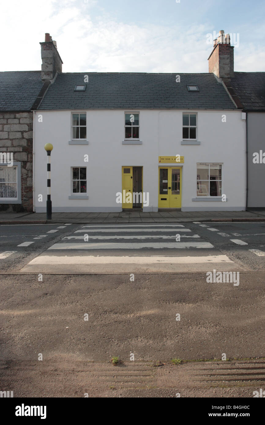 Zebra crossing leading to a whitewashed house with bright yellow doors ...