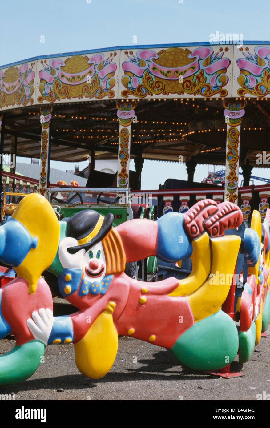 Large brightly colored plastic clown figures in front of fairground ...