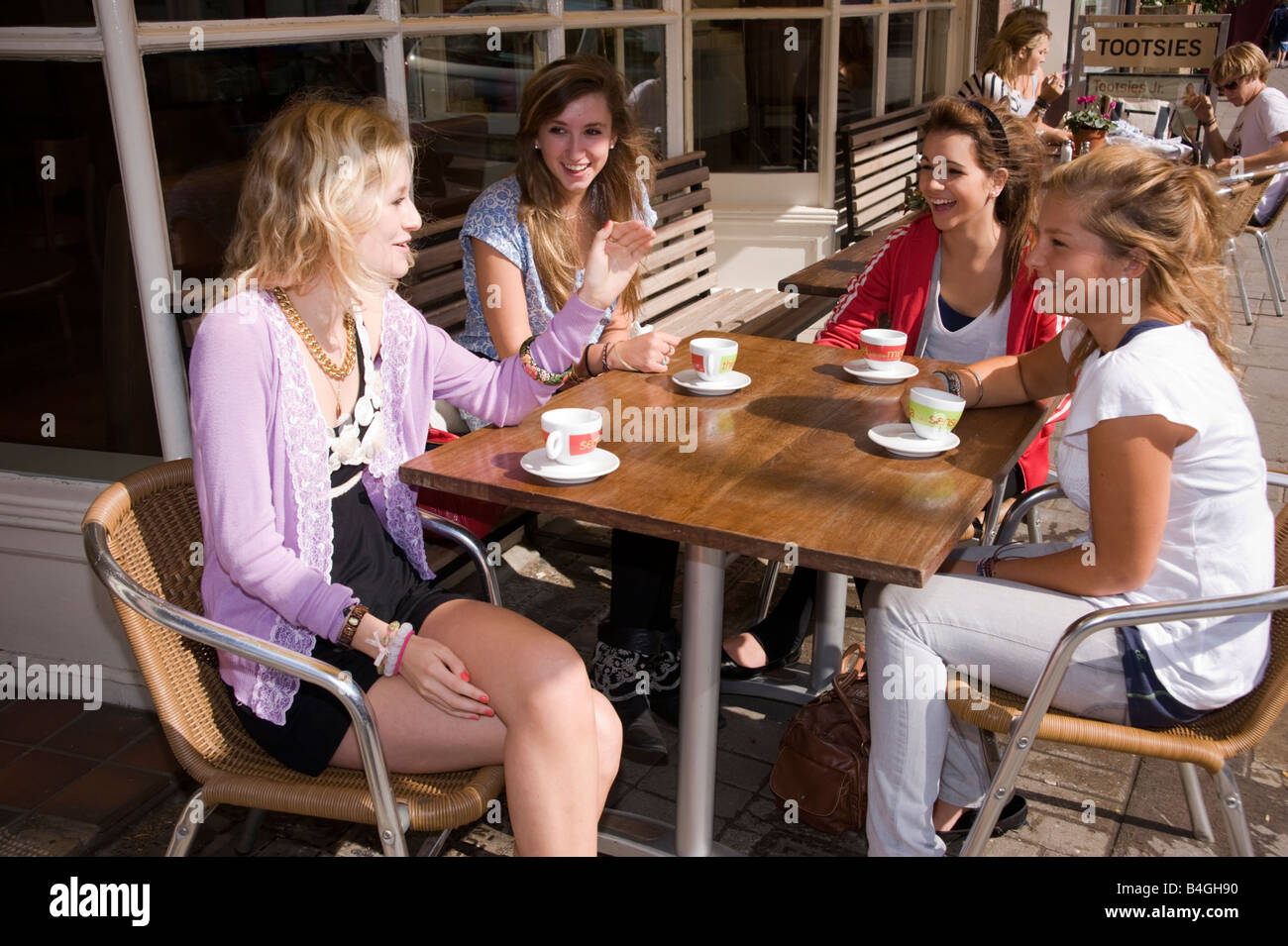 group of teenage girls having a coffee at an outdoor cafe Stock Photo ...