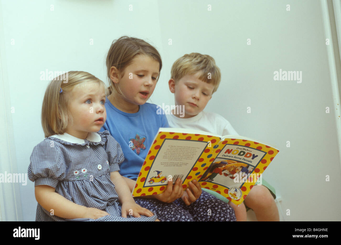 girl reading to younger children Stock Photo - Alamy