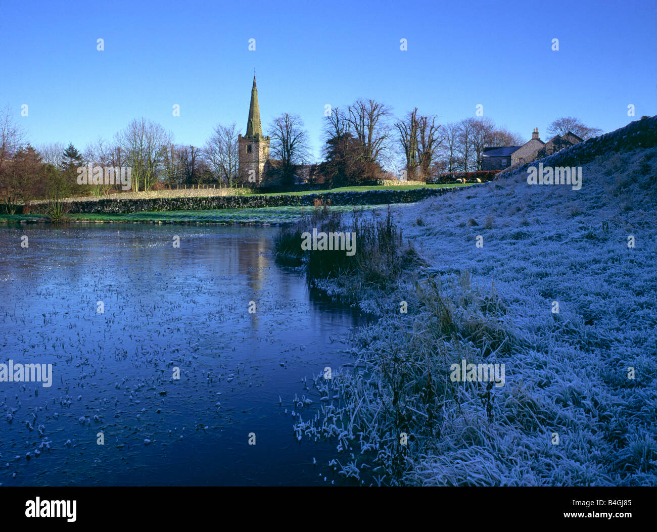 A frosty winter morning with ice on Fere Mere (the village pond) at ...