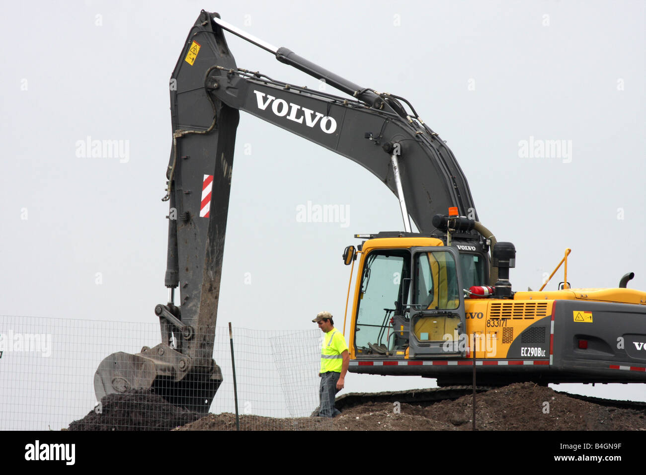 Waste Management Landfill worker on a backhoe reworking the trash in ...