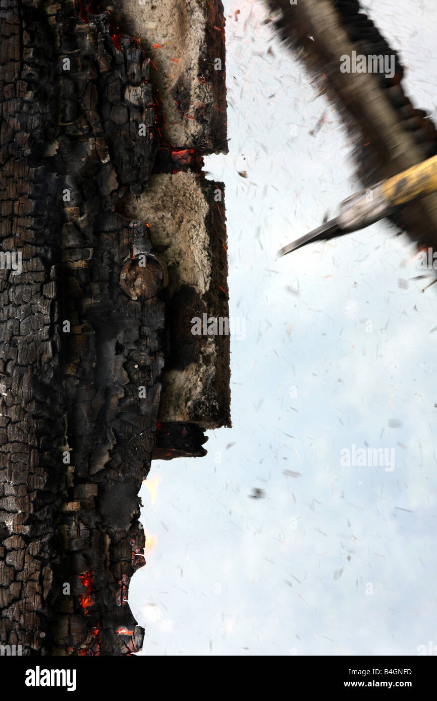 The pick pole of a fire fighter pulling the siding of a house on fire ...