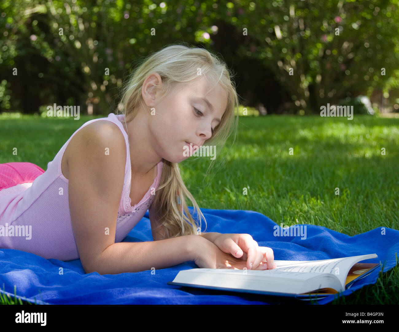 Child reading a book on the lawn Stock Photo - Alamy