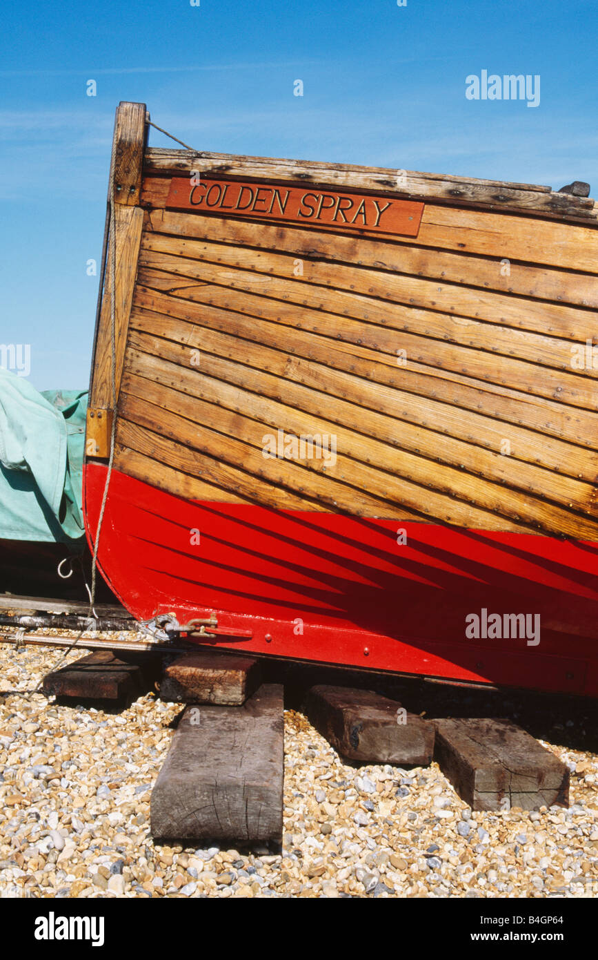 Close up of wooden boat with red painted keel on wooden sleepers on ...