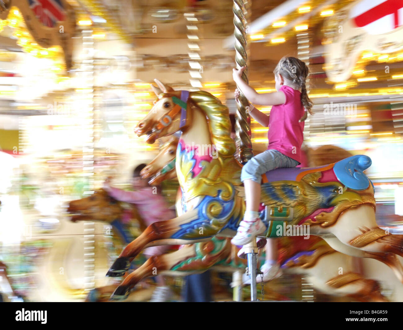 young girl riding horse carousel Stock Photo - Alamy