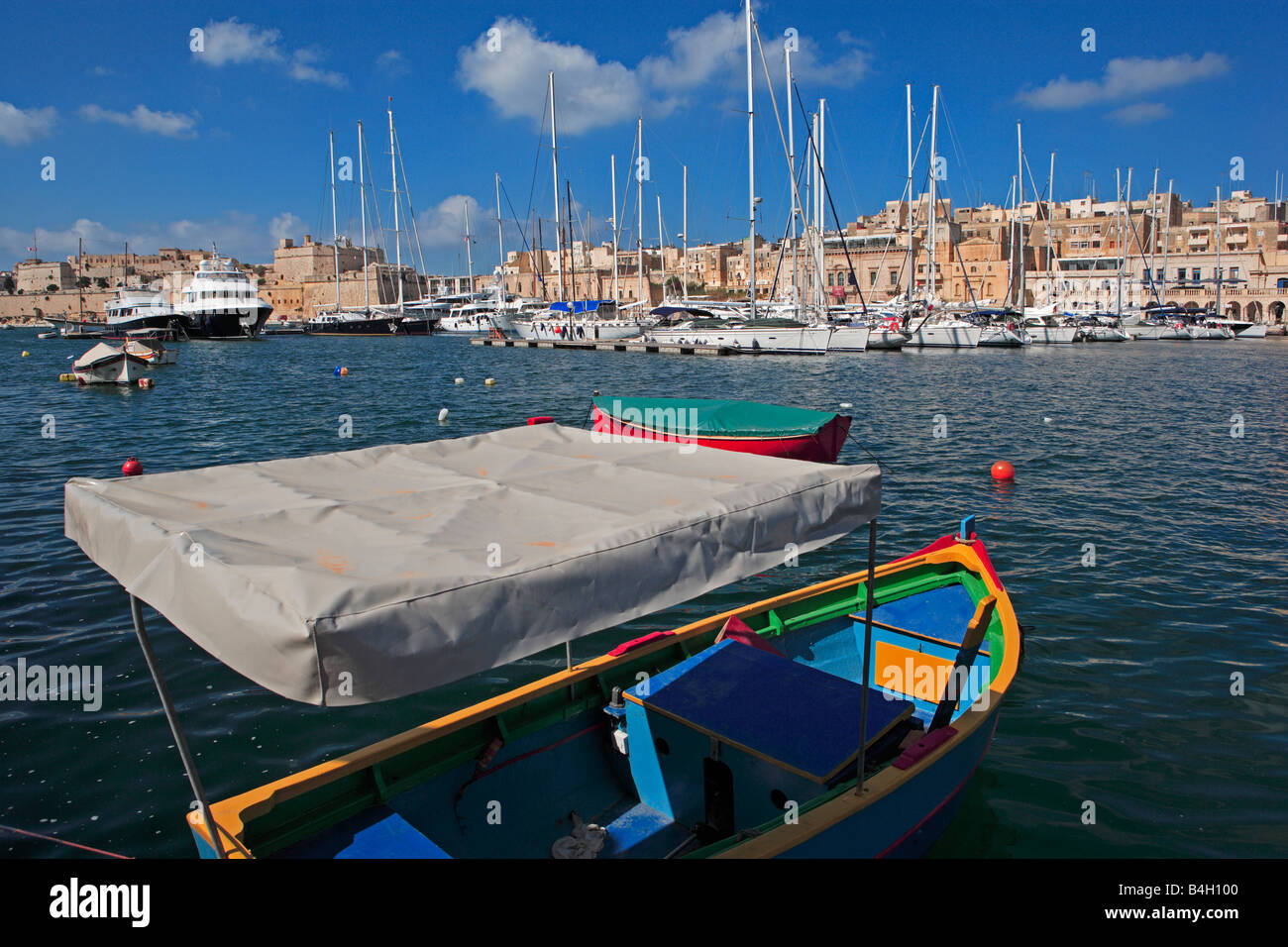 Luzzu, traditional Maltese boat, with Vittoriosa across Dockyard Creek ...