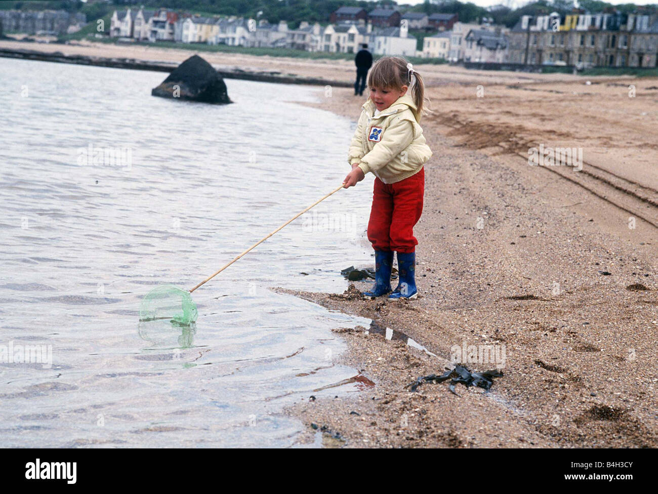 North Berwick beach 1987 girl fishing with net on stick Stock Photo - Alamy
