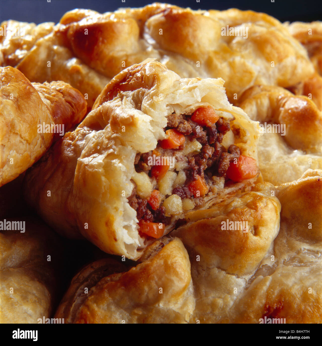 Pile of traditional Cornish pasties, one with a cut face showing the ...