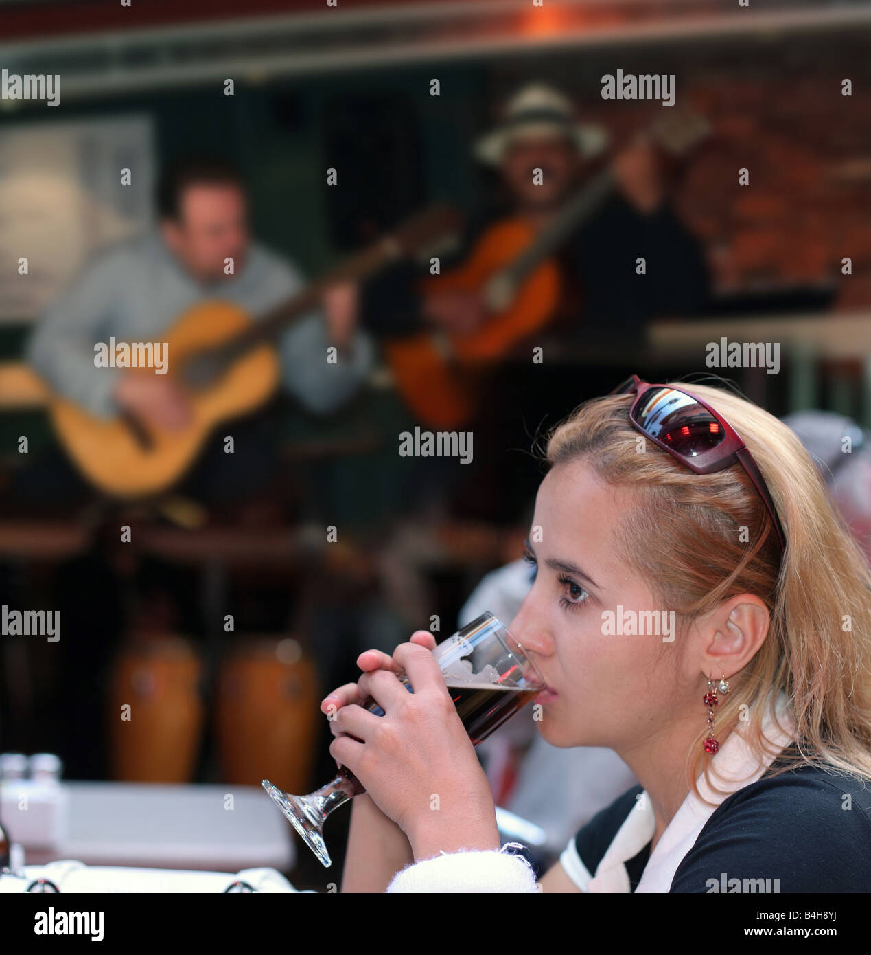 Girl drinking beer alone in a restaurant with live music Stock Photo ...
