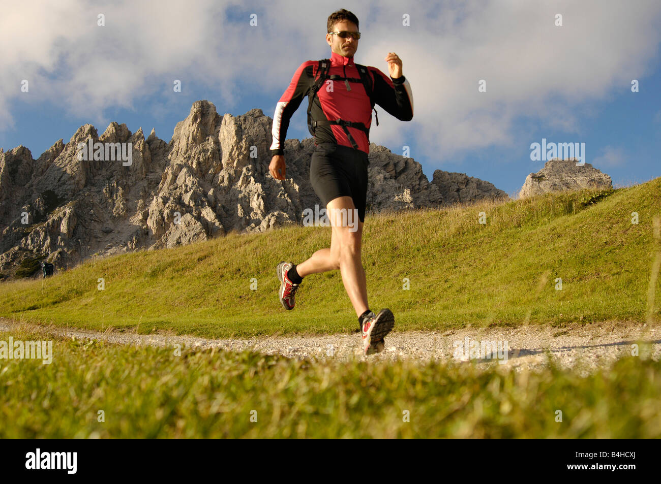 Mid adult man running in field, Trentino-Alto Adige, Italy Stock Photo ...