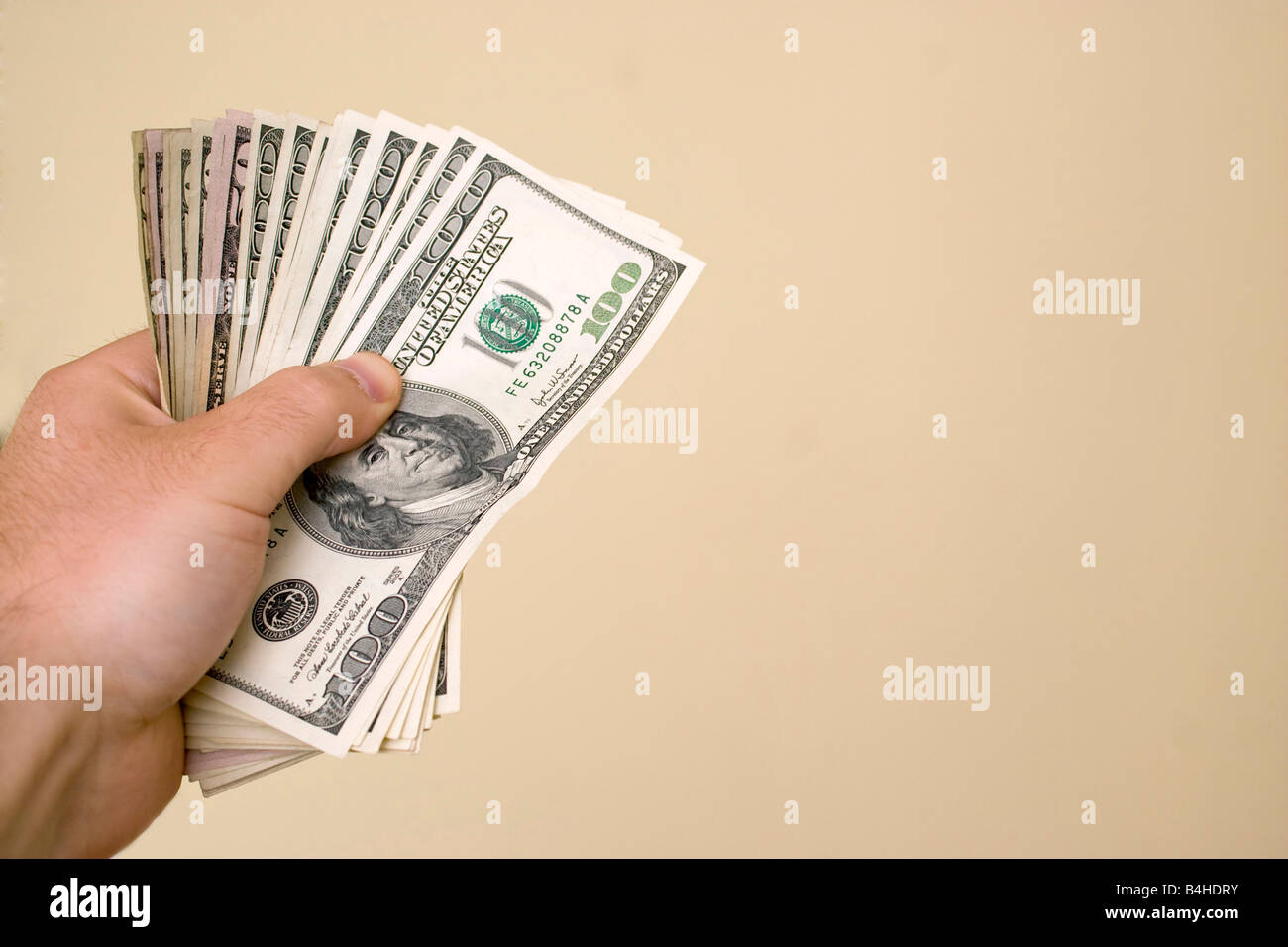 A handful of cash isolated over a gold background Stock Photo - Alamy