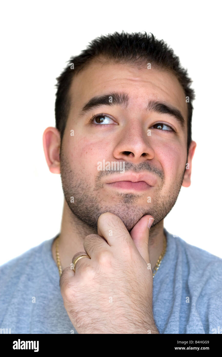 A young man with his hand on his chin thinking an important decision ...