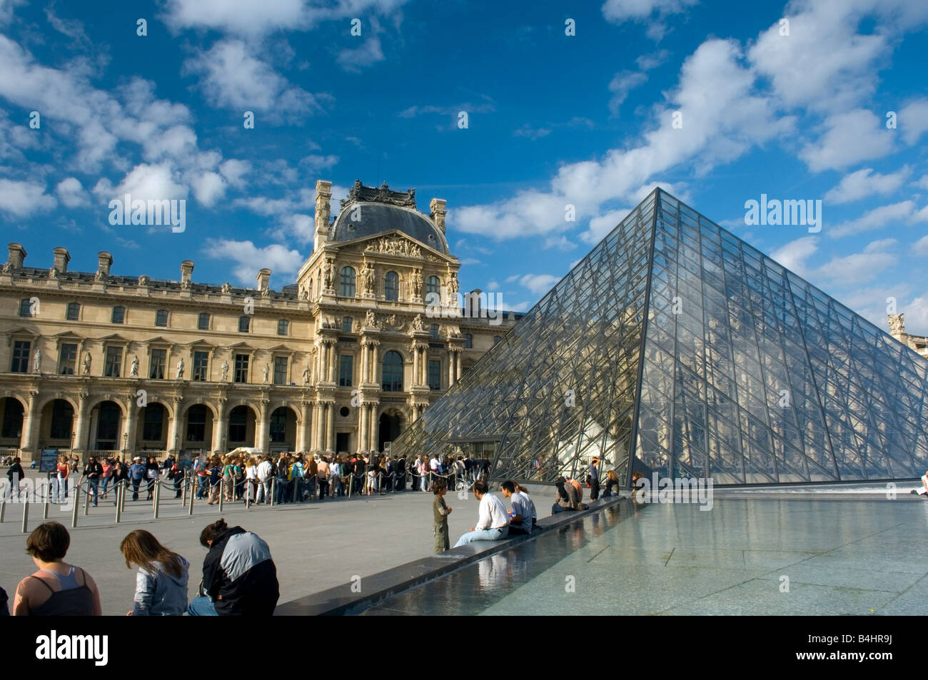 Tourists queue at the Pyramid entrance to the Musée du Louvre, Paris ...
