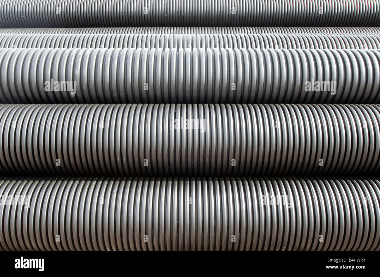 Rows of black ribbed tubes on construction site Stock Photo - Alamy
