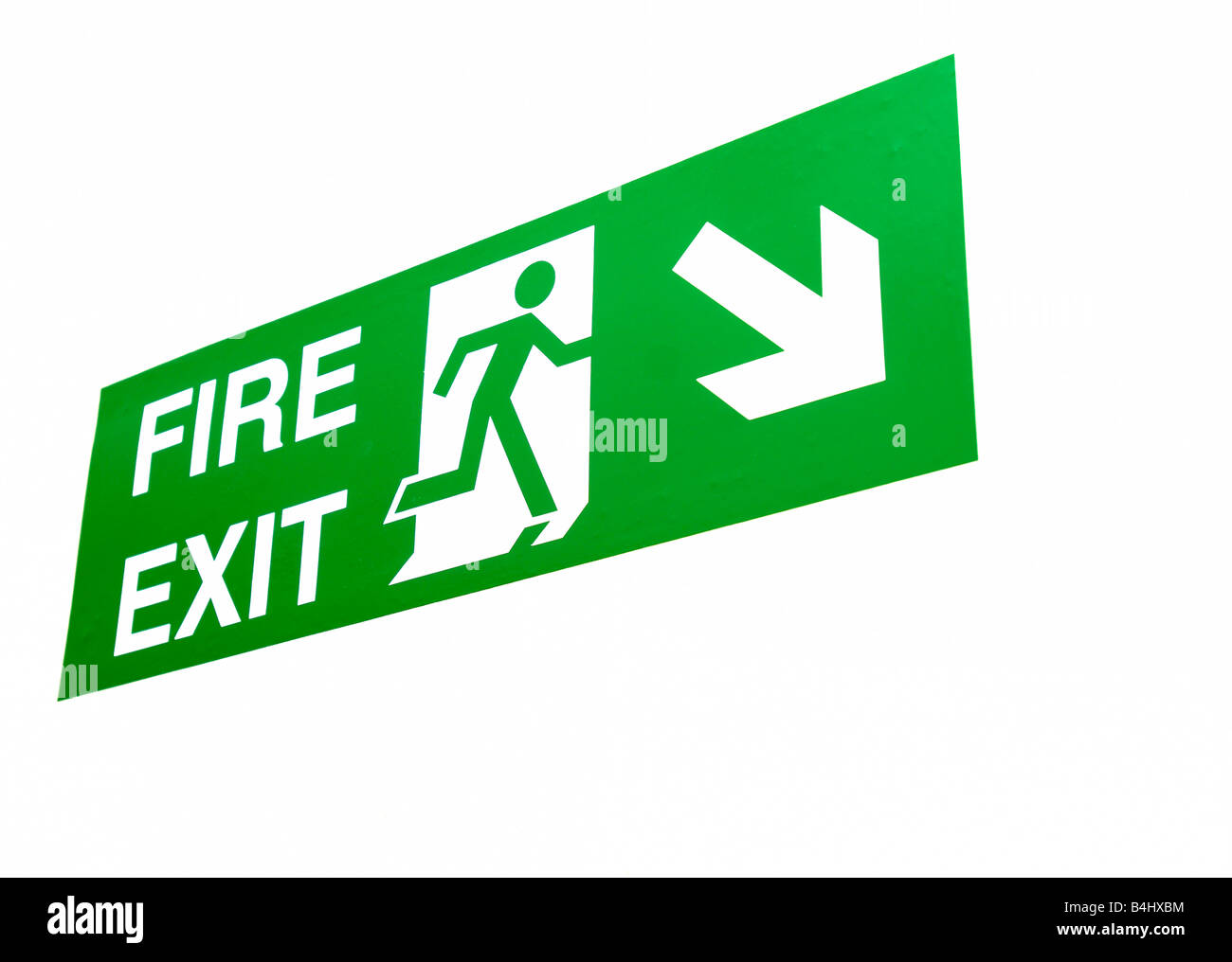 Green fire exit sign on white wall Stock Photo - Alamy