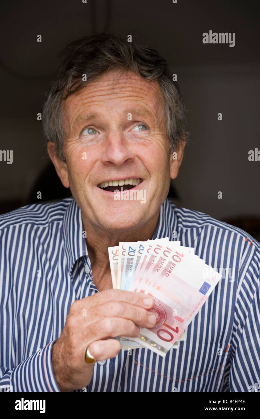 Happy man holding euros hi-res stock photography and images - Alamy