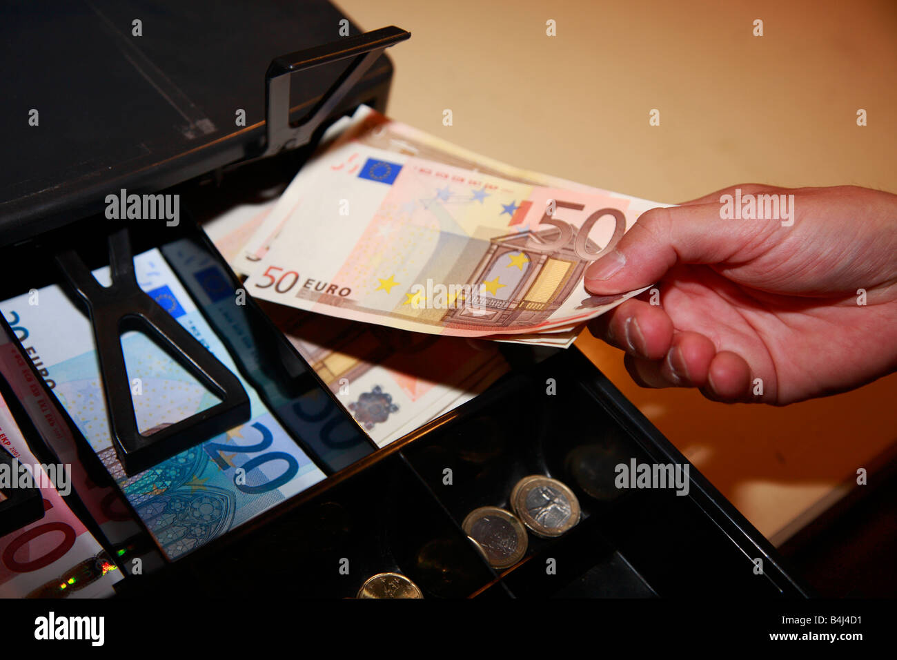 putting money Euros in till Stock Photo - Alamy