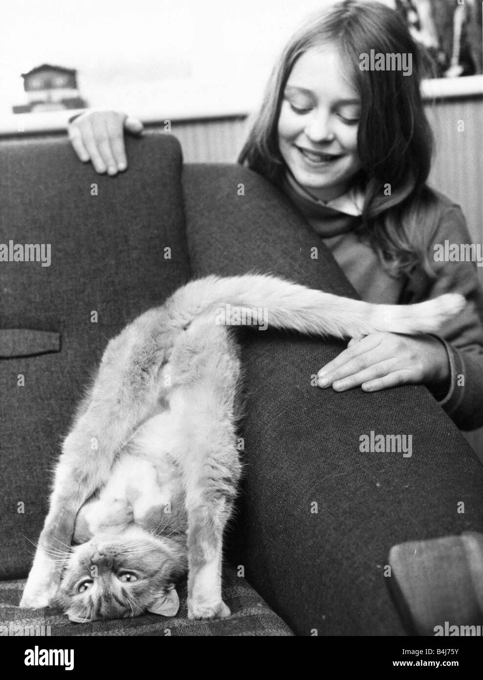 Little girl watches her cat bend himself into unusual positions ...