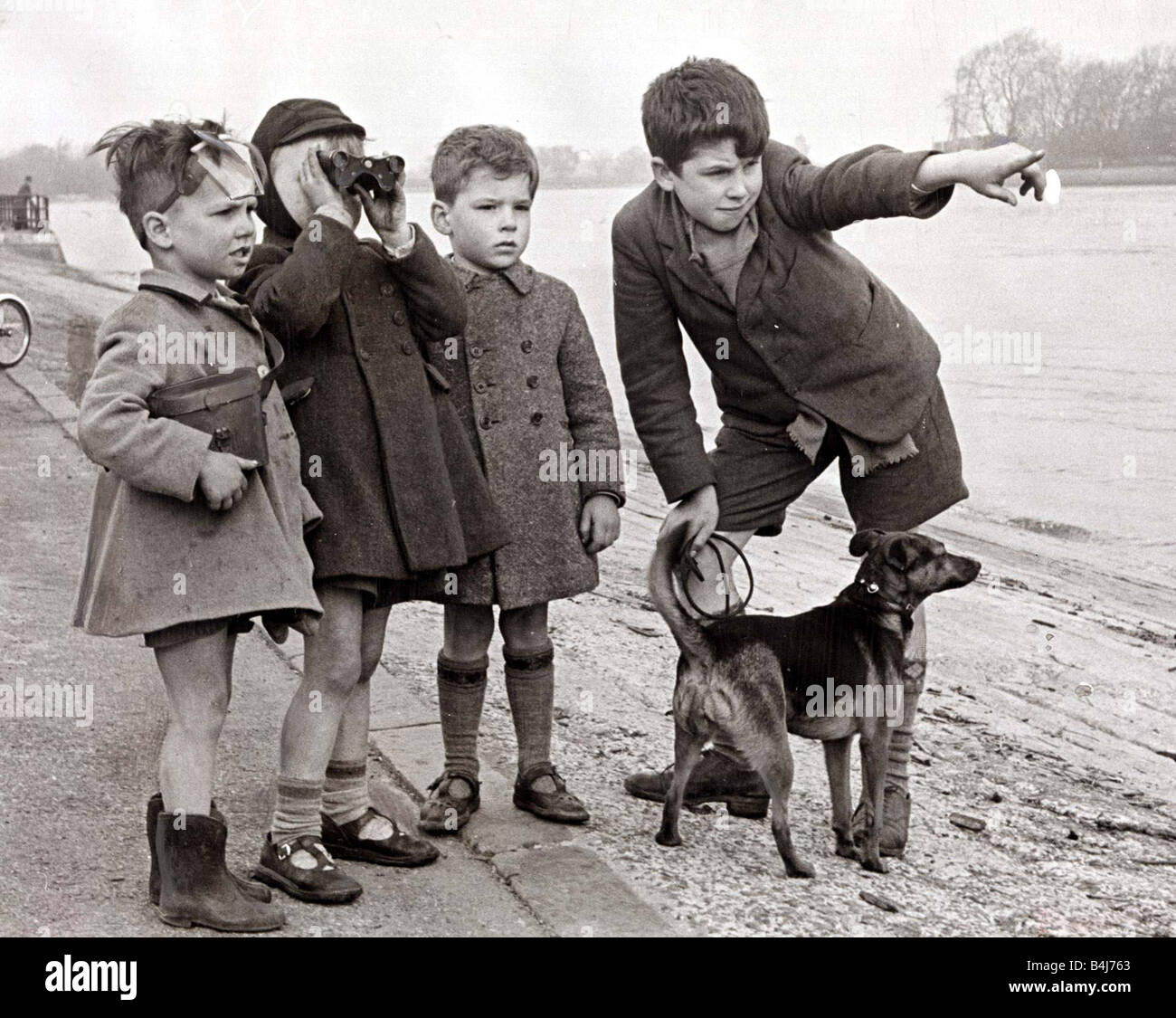A group of children look to the distance using a pair of binoculars One ...