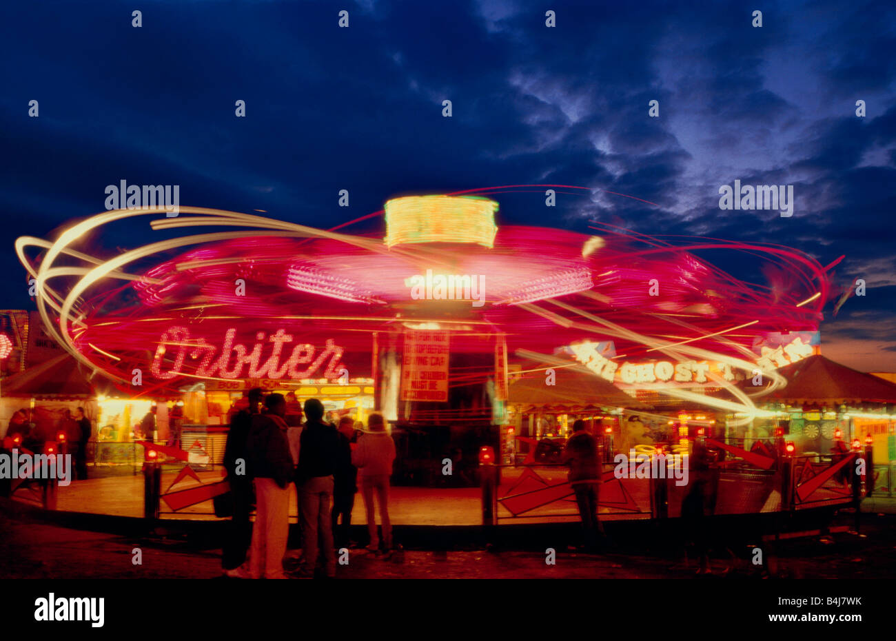 Spinning fairground ride at night England UK Stock Photo - Alamy