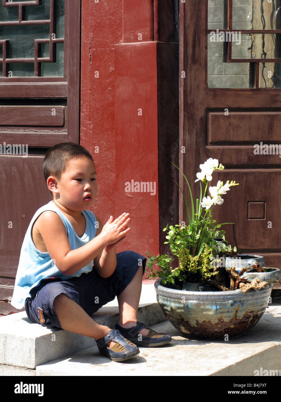 A Chinese boy sitting on the street in Beijing China Stock Photo - Alamy