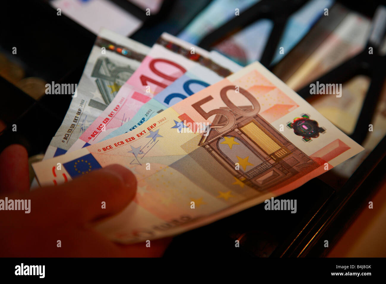 putting money Euros in till Stock Photo - Alamy