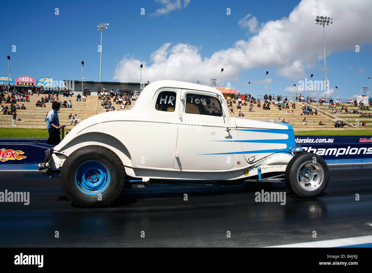 A hot rod car sitting on the start line at a drag race motorsport event ...