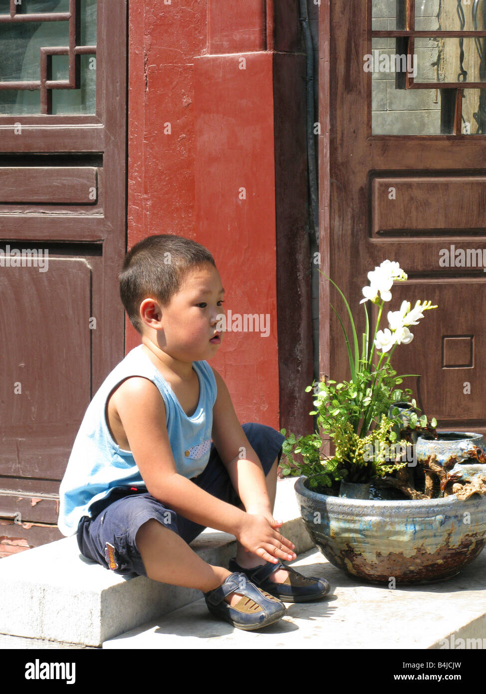 A Chinese boy sitting on the street in Beijing China Stock Photo - Alamy