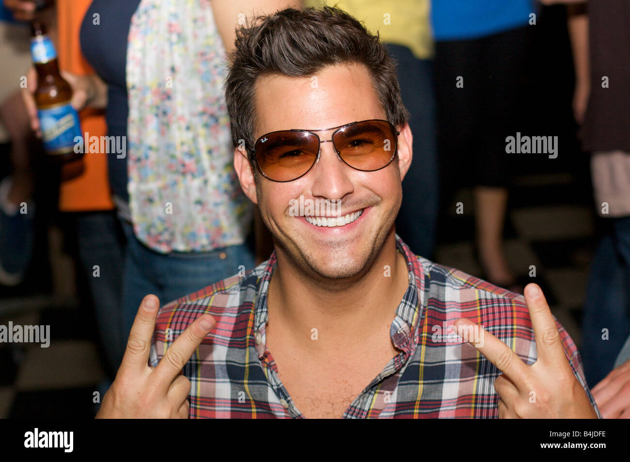 Man wearing sunglasses giving two peace signs Stock Photo - Alamy